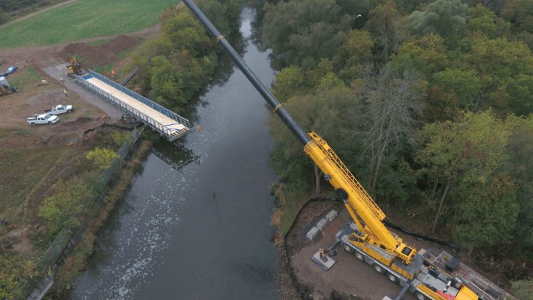 Temporary bridge carries utility pipes across Ontario river